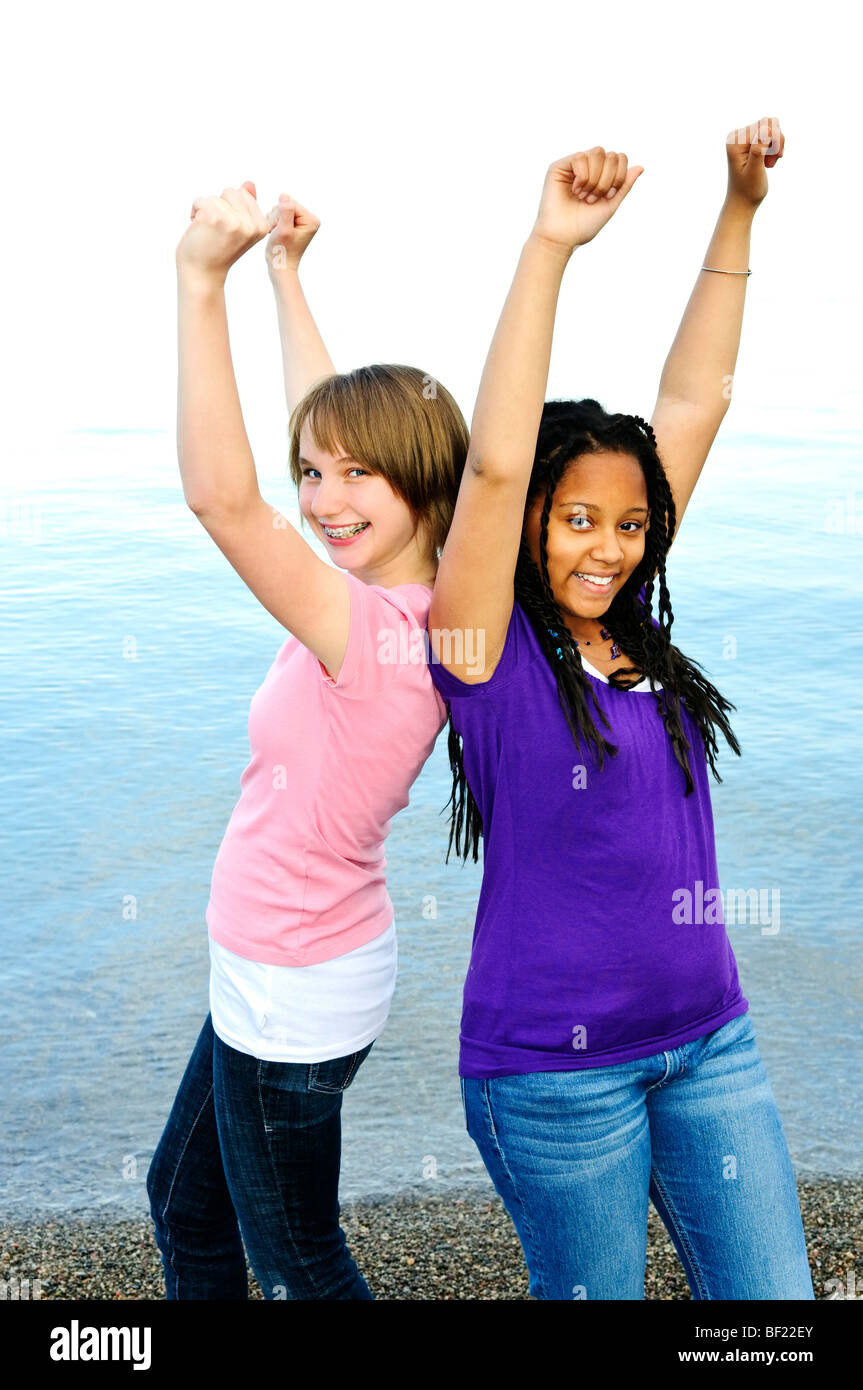 Portrait of two teenage girl friends raising arms Stock Photo - Alamy