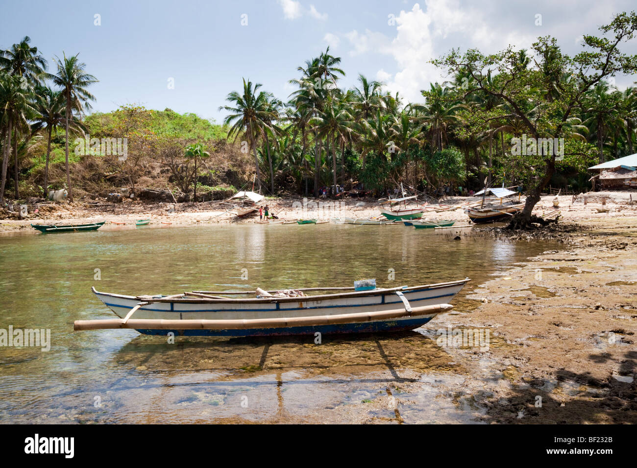 Traditional fishing boats pulled onto the beach. Sinapsapan village ...