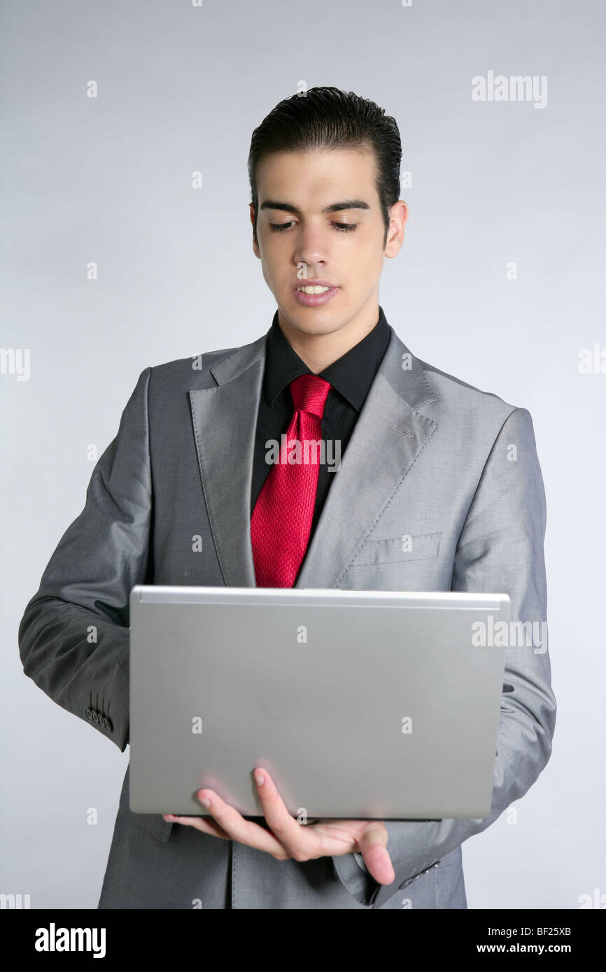 Businessman in gray suit holding laptop computer at studio Stock Photo ...
