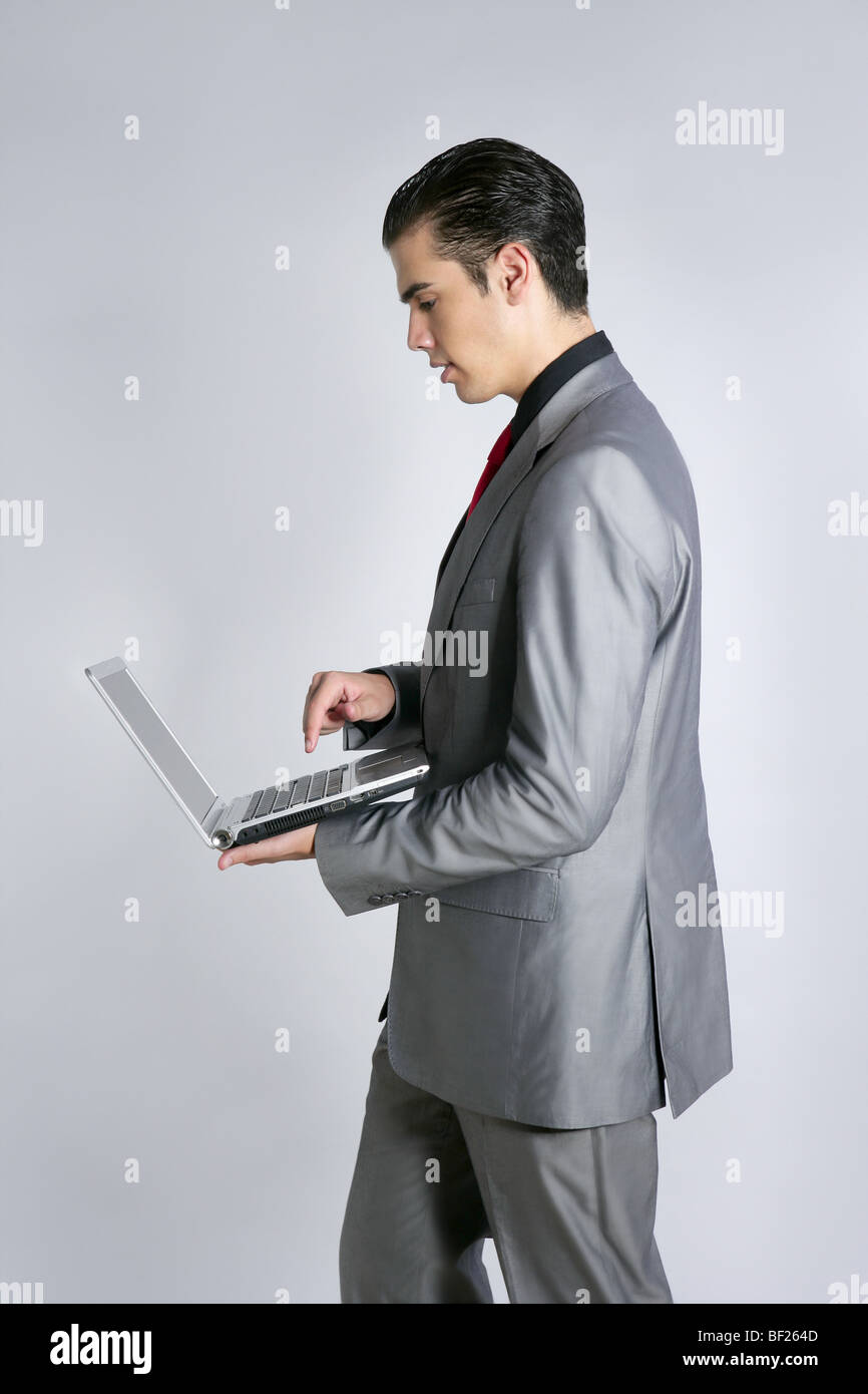 Businessman in gray suit holding laptop computer at studio Stock Photo ...