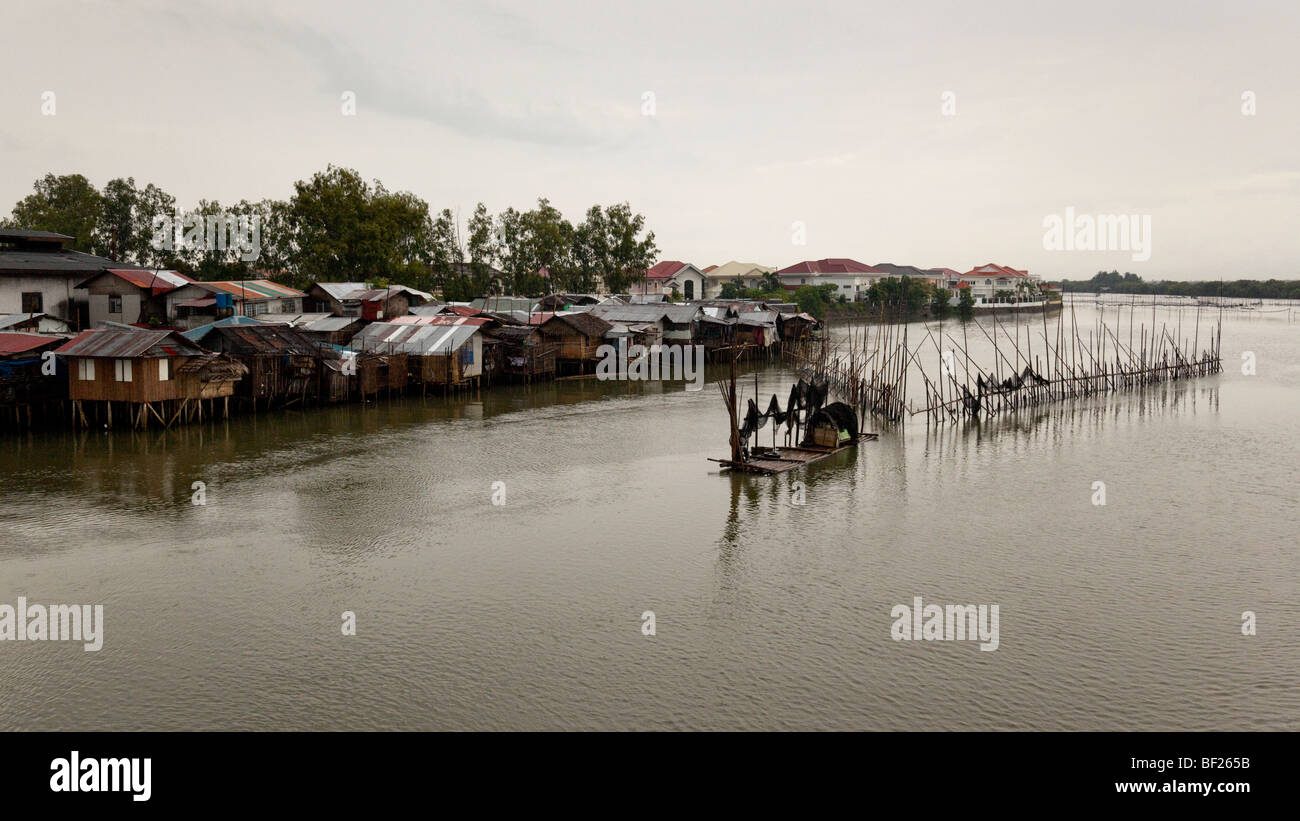 Shanty houses on stilts next to bamboo fish traps in a river. Iloilo ...
