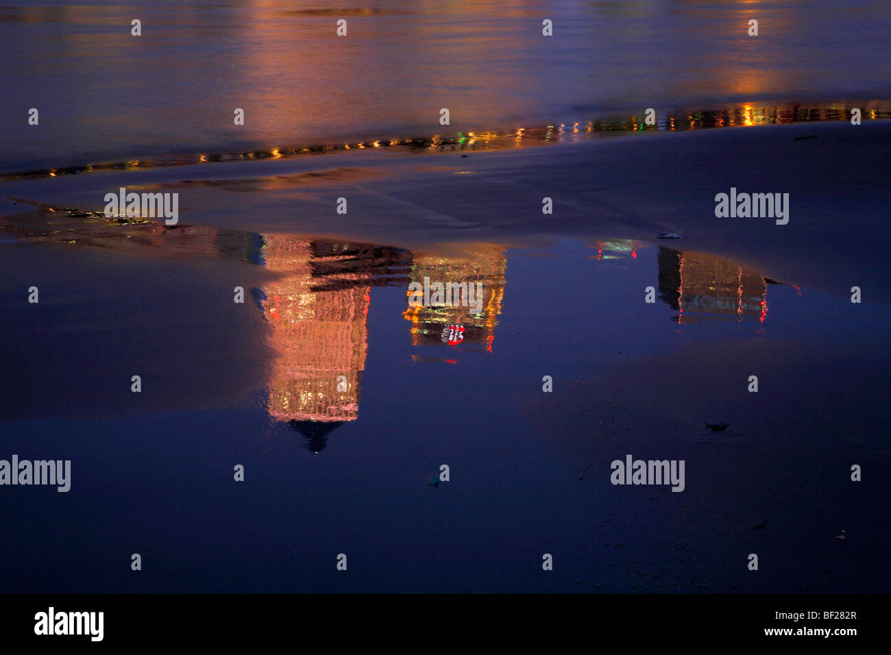 Reflection of Canary Wharf skyline on the wet foreshore beach of the ...