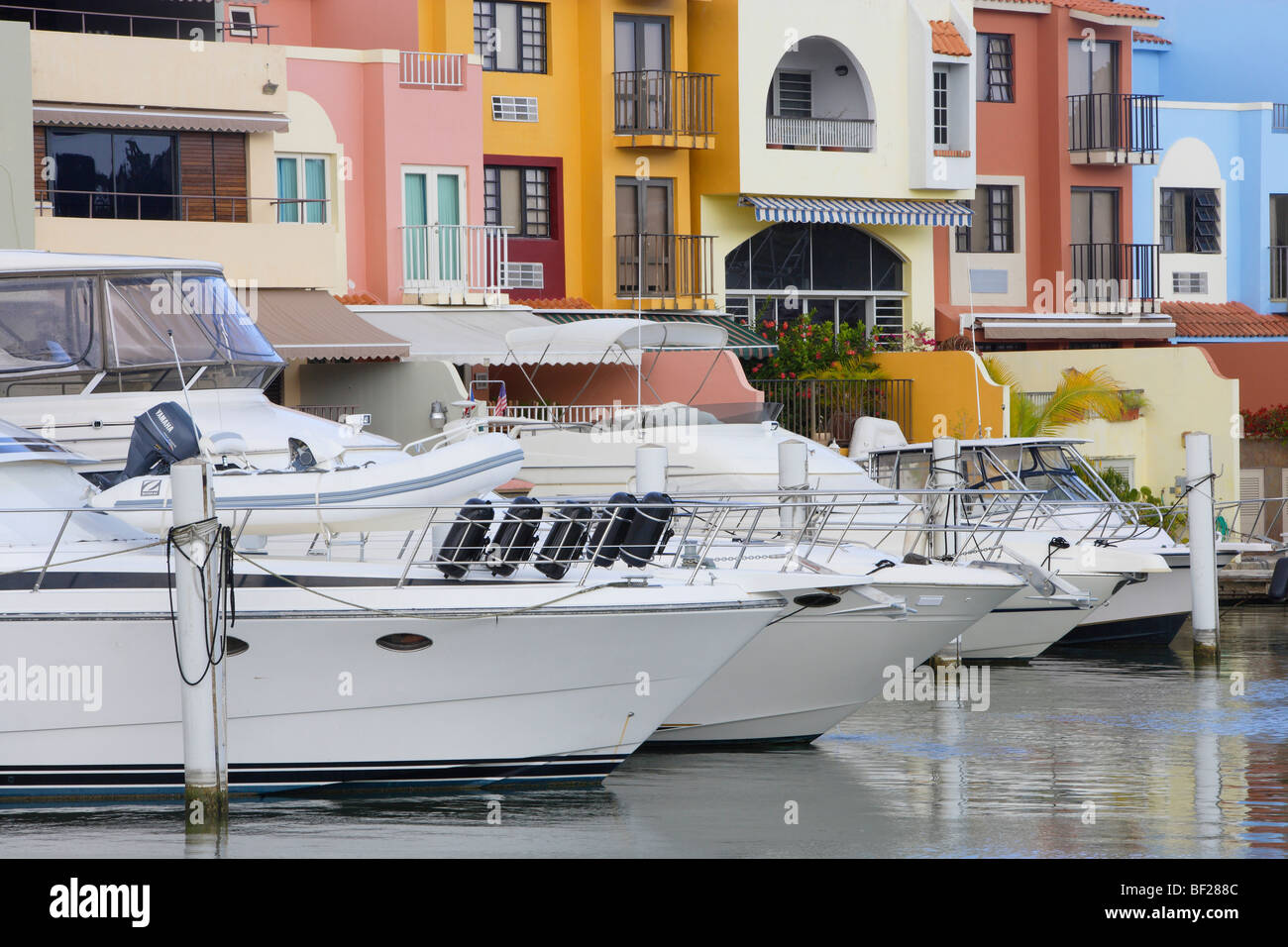 Boats are moored at Palmas del Mar harbour in front of colourful houses ...