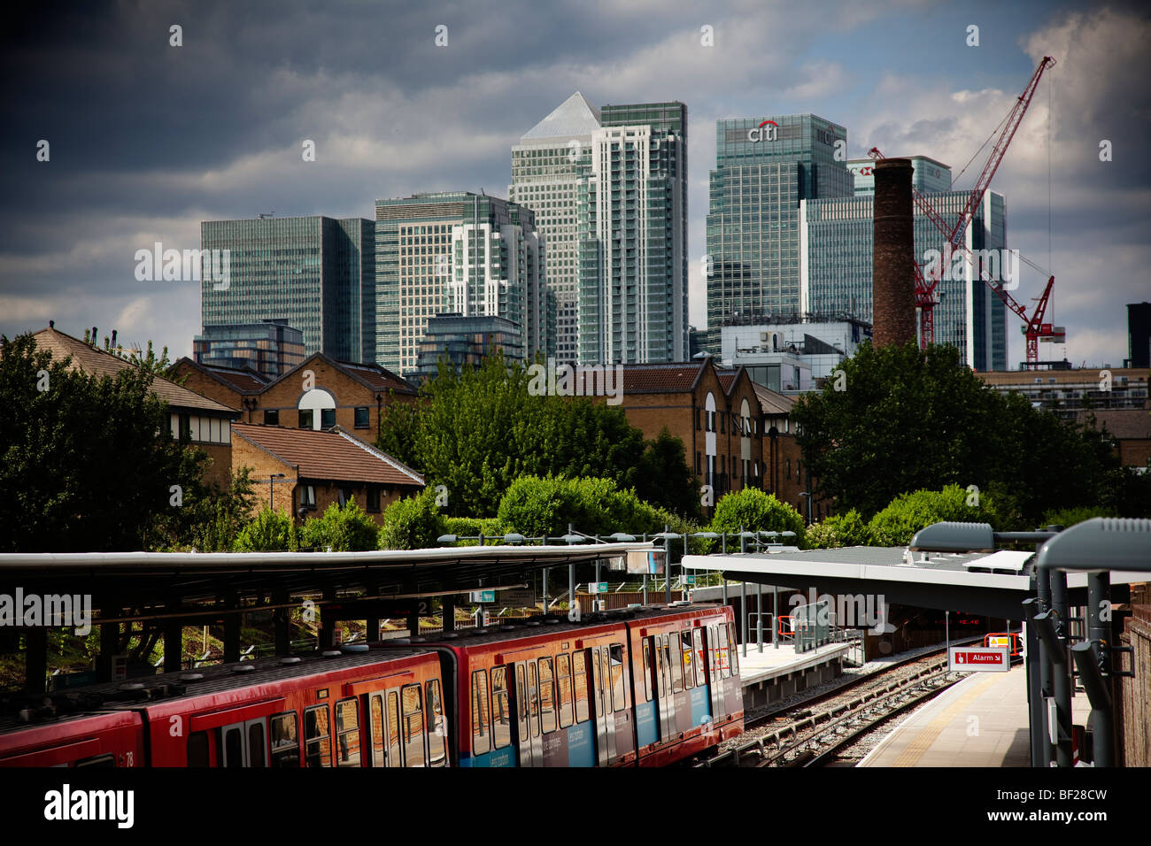 Skyscrapers of Canary Wharf stand against dark clouds and blue sky ...