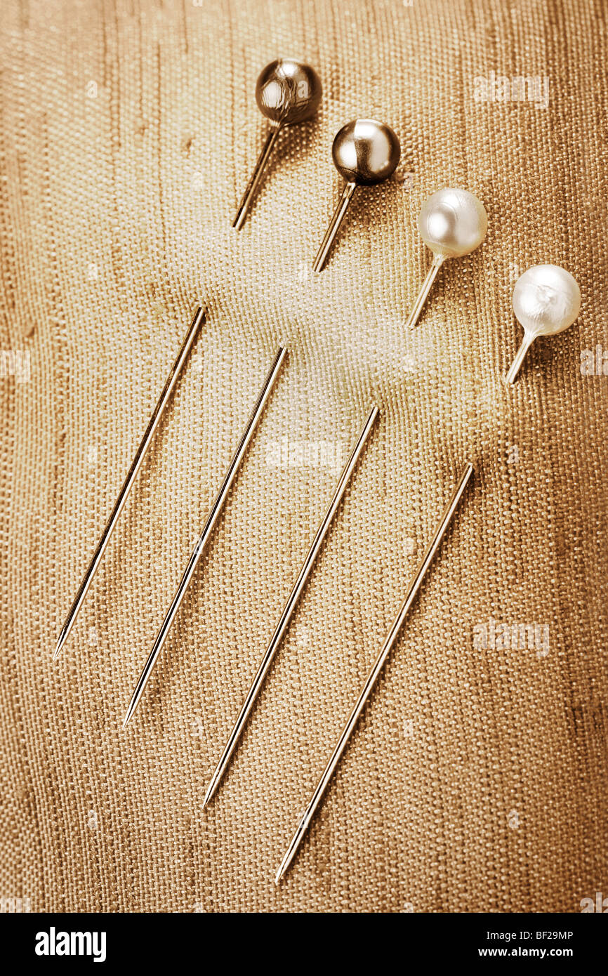 four sewing pins in a row Stock Photo - Alamy