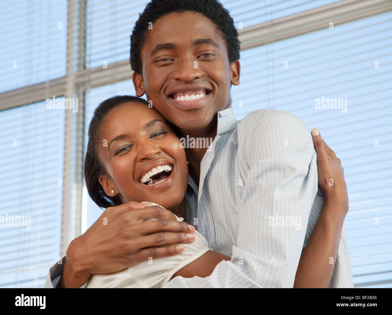 Work colleagues embracing in office, Cape Town, Western Cape Province ...