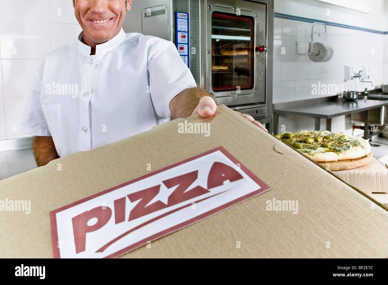 Chef holding a pizza box Stock Photo - Alamy