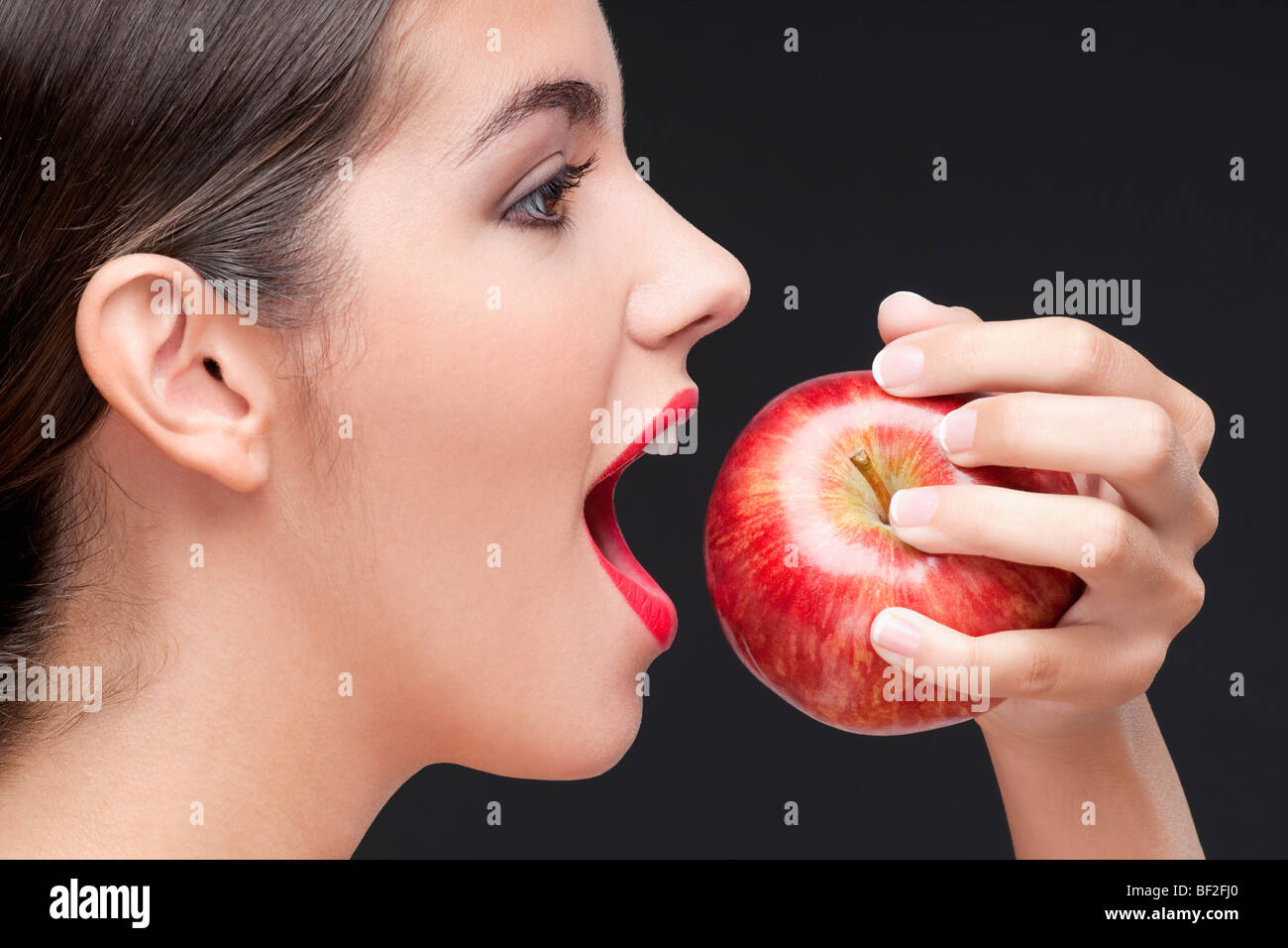 Close-up of a woman eating a red apple Stock Photo - Alamy