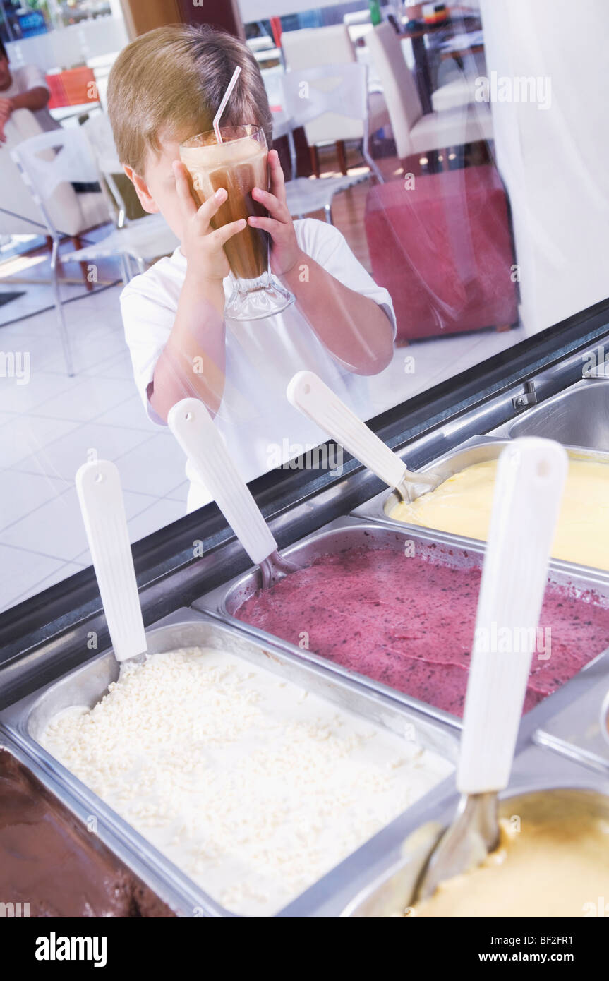 Boy holding a glass of chocolate milkshake in an ice cream parlor Stock ...