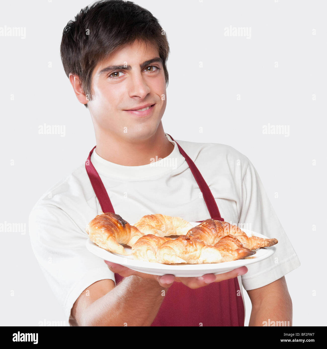 Portrait of a man holding croissants on a plate Stock Photo - Alamy