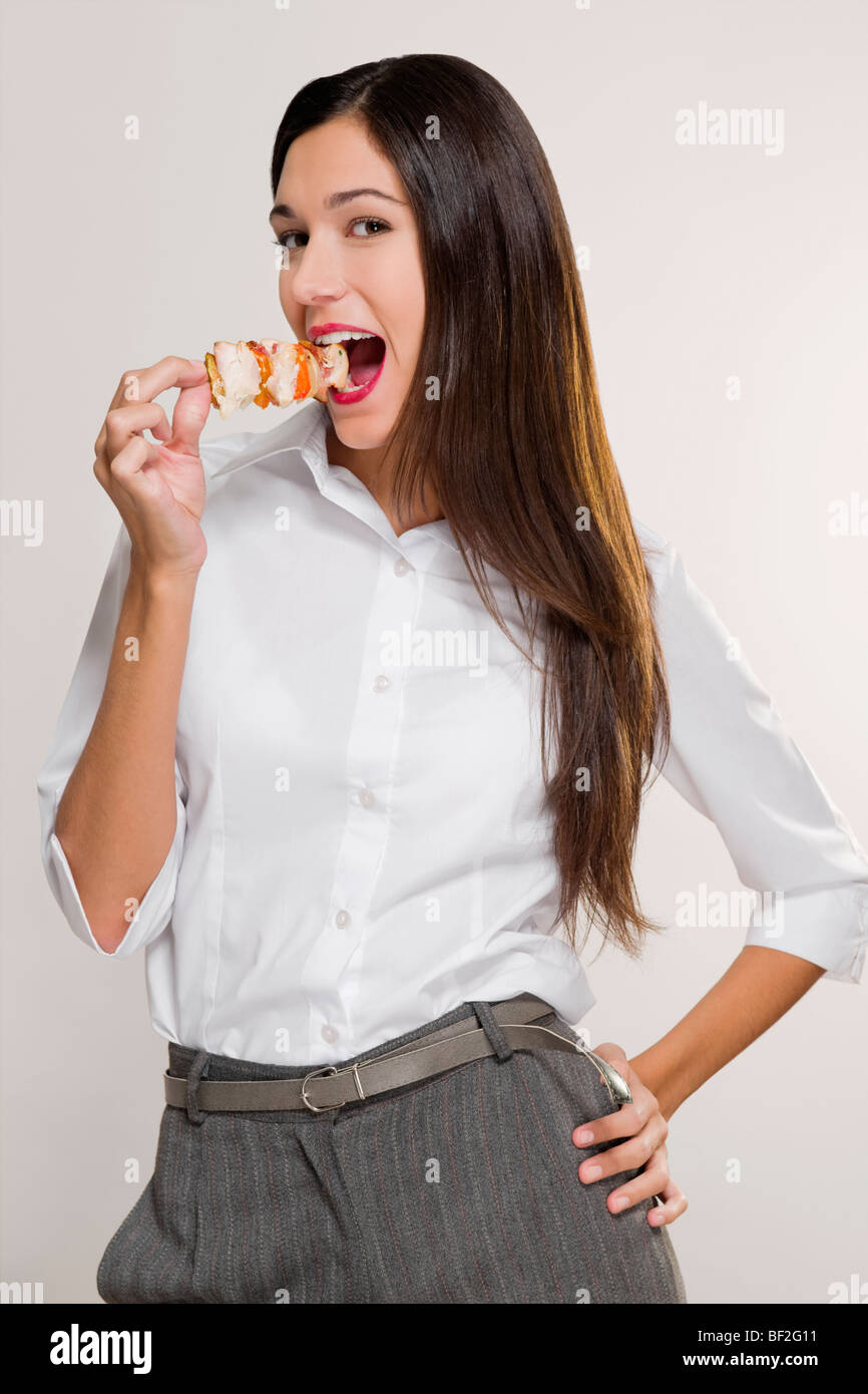 Portrait of a woman eating a shish kebab Stock Photo - Alamy