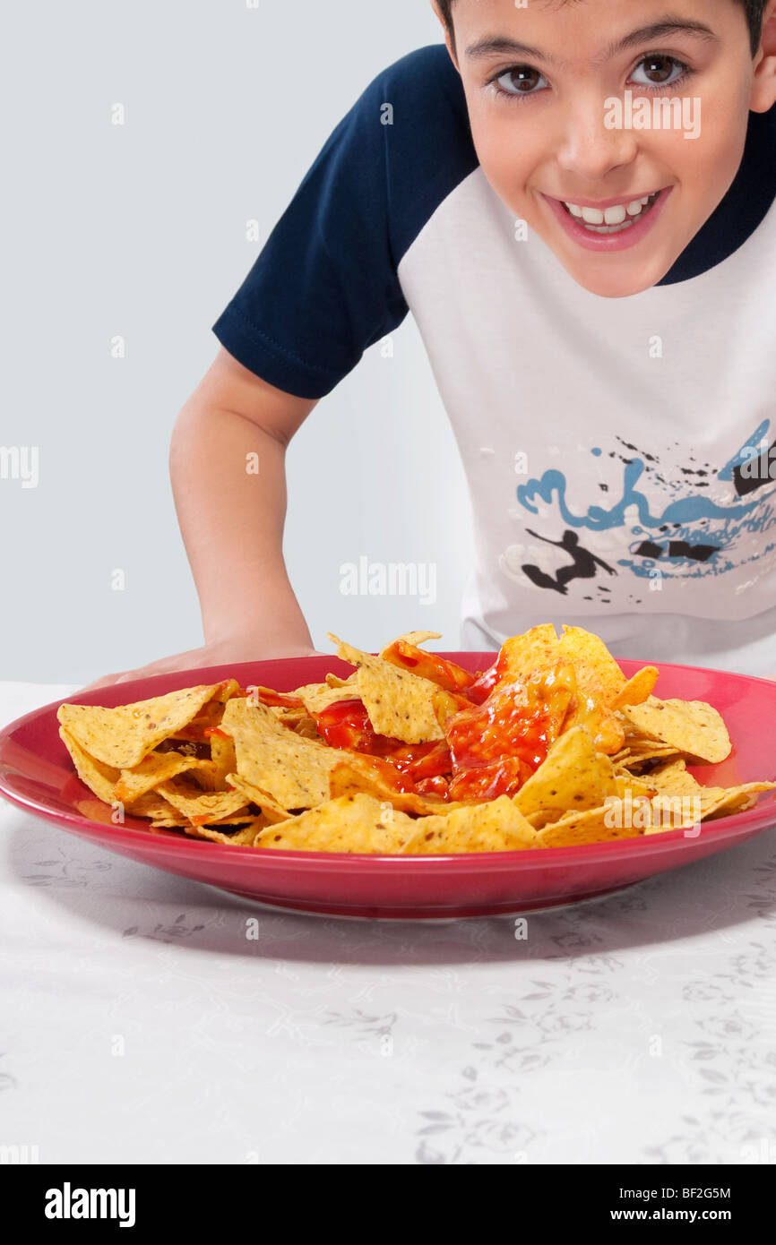 Close-up of a boy looking at a platter of nachos Stock Photo - Alamy