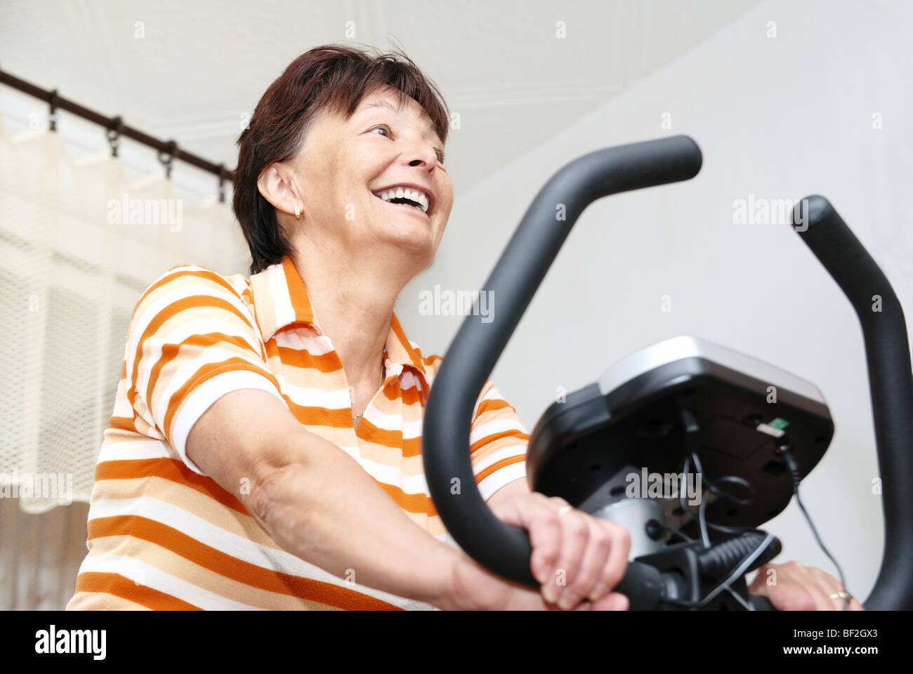 Senior woman exercise on spinning bicycle at home Stock Photo - Alamy