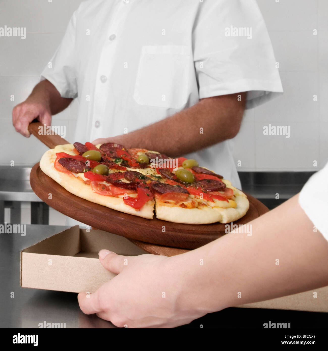 Two chefs preparing pizza in the kitchen Stock Photo - Alamy