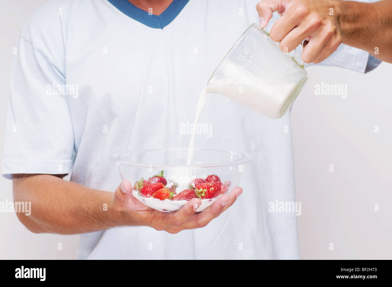 Mid section view of a man pouring milk on strawberries Stock Photo - Alamy