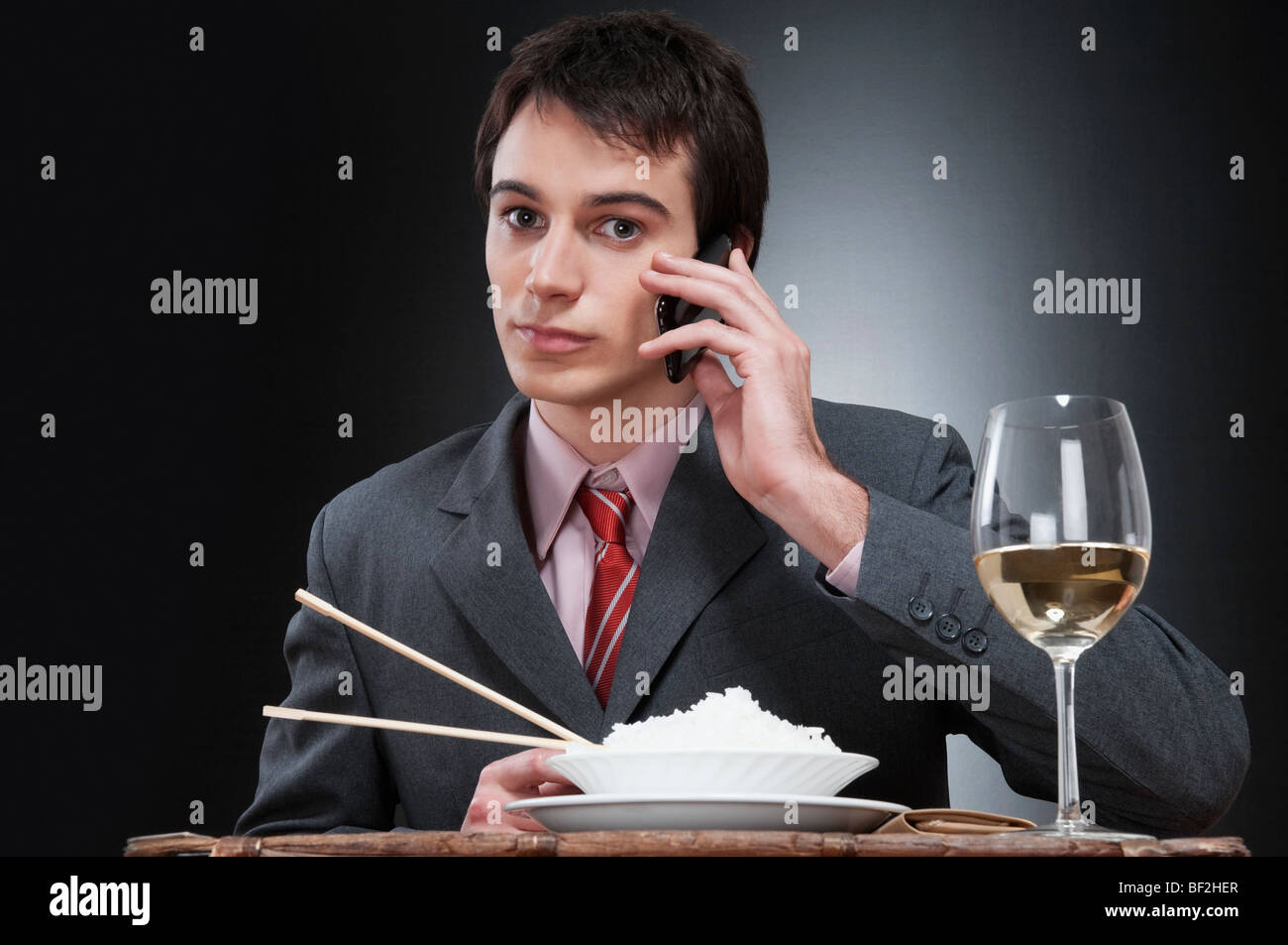 Businessman talking on a mobile phone while eating Stock Photo - Alamy