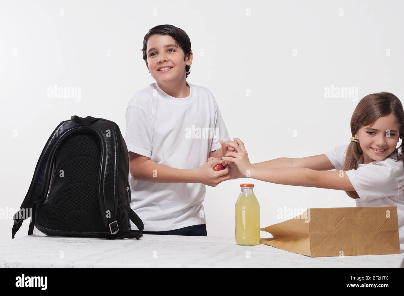 Close-up of a boy and a girl fighting over an apple for lunch Stock ...