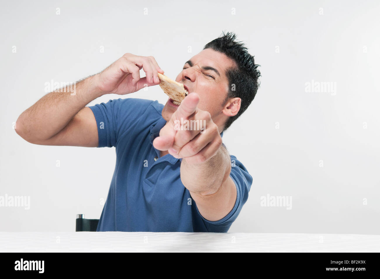 Man eating pizza and pointing Stock Photo - Alamy