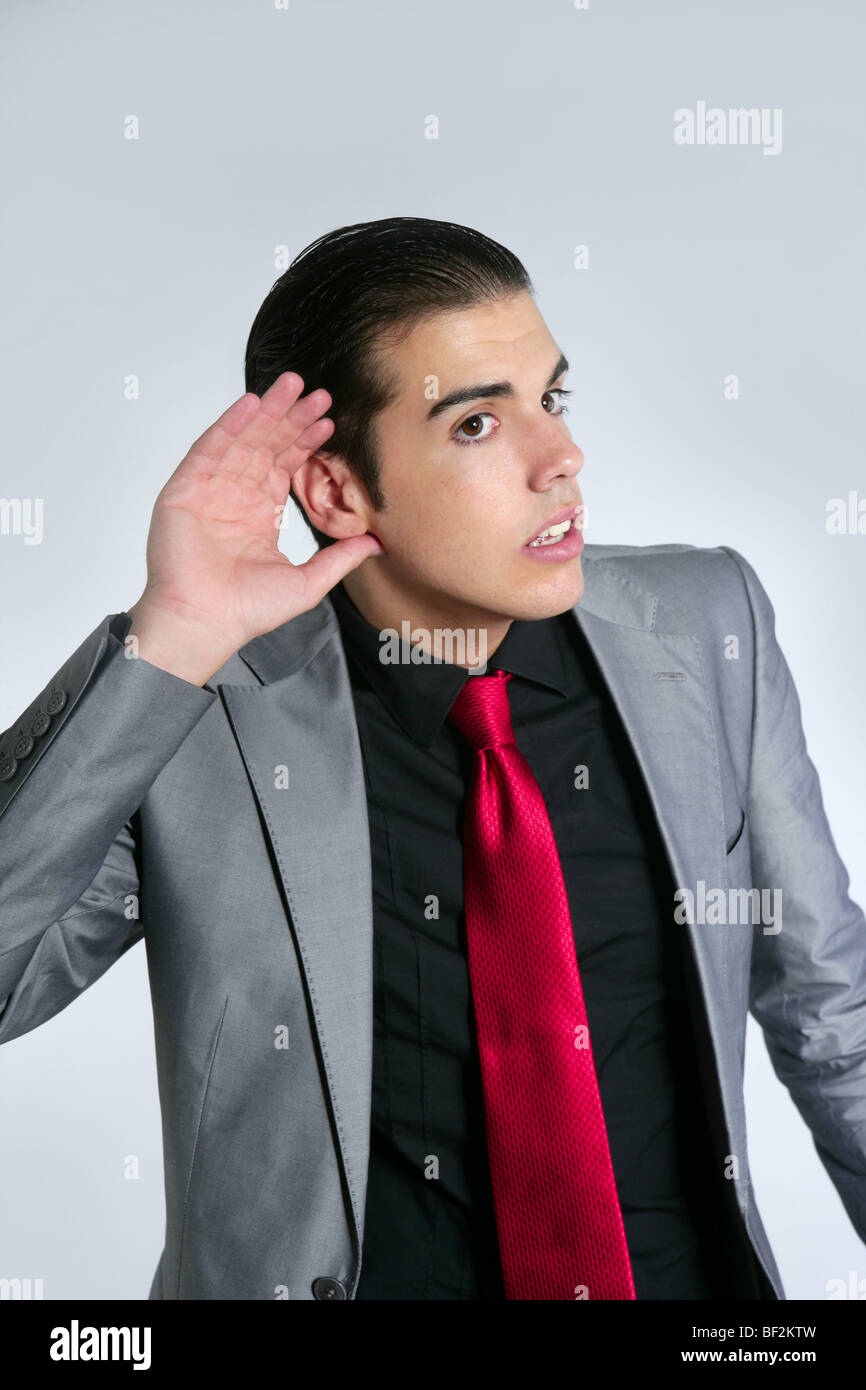 Businessman with hand in ear as a deafness sign gesture Stock Photo - Alamy