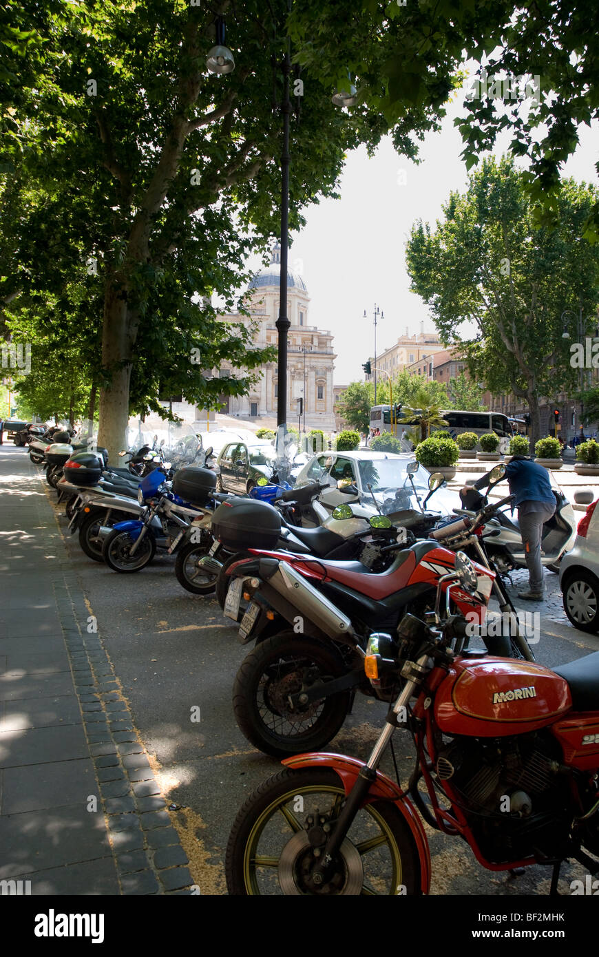Motor cycles and scooters parked under the shade of trees in Piazza ...