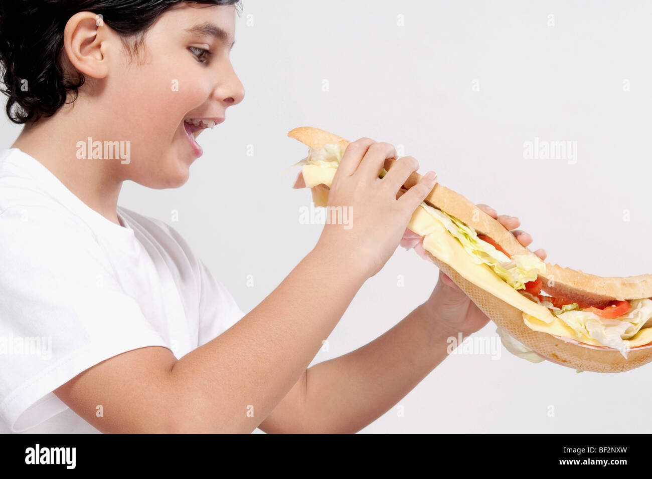 Boy eating a submarine sandwich Stock Photo - Alamy