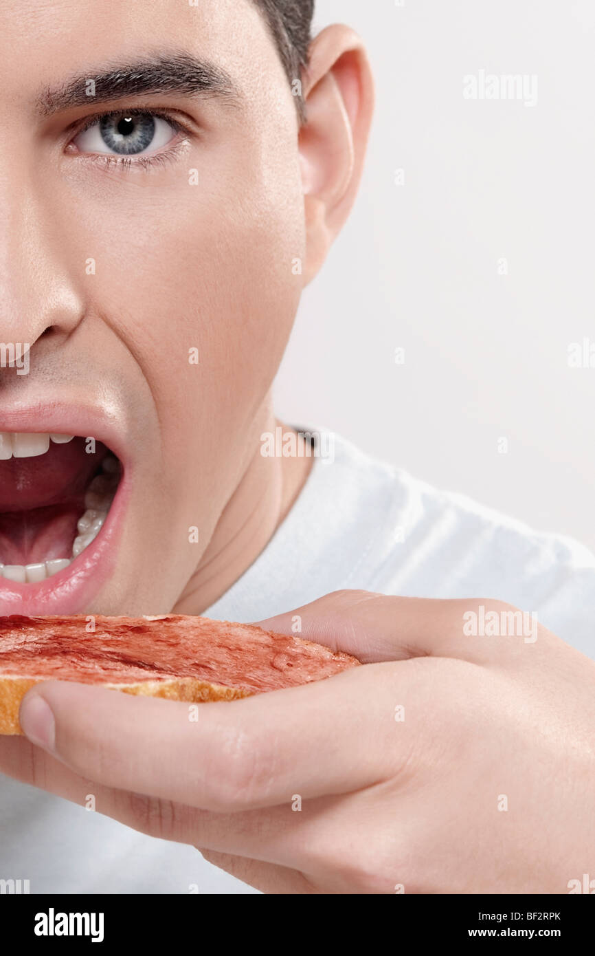 Man eating jam on toast Stock Photo - Alamy