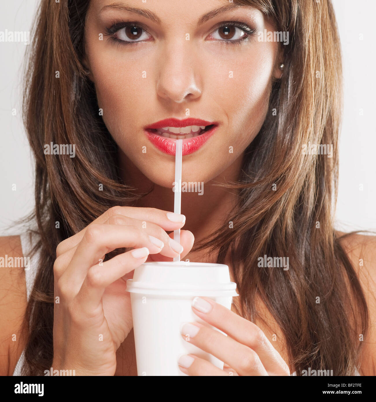 Portrait of a woman drinking coffee with a straw Stock Photo - Alamy