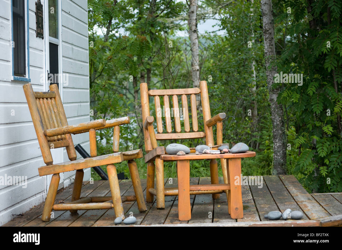 two pine log chairs on porch with stacks of gathered rocks Stock Photo ...