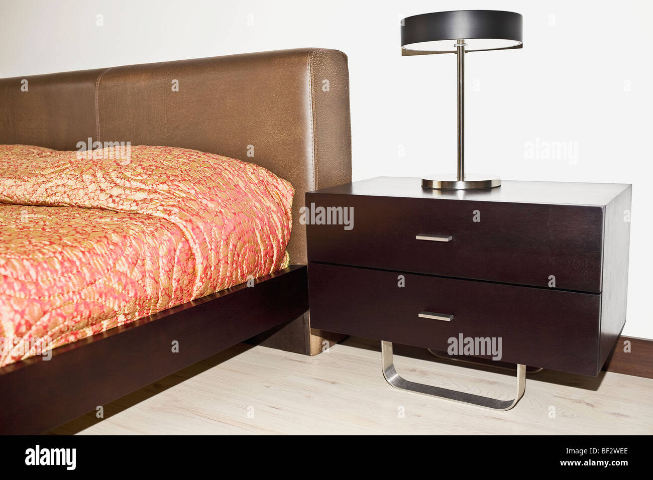 Lamp on a night table beside a bed Stock Photo - Alamy