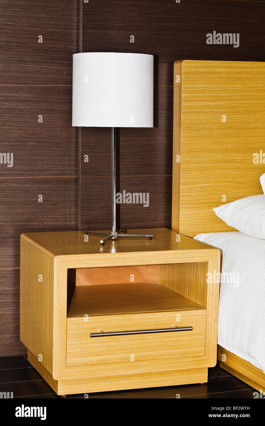 Lamp on a night table beside a bed Stock Photo - Alamy