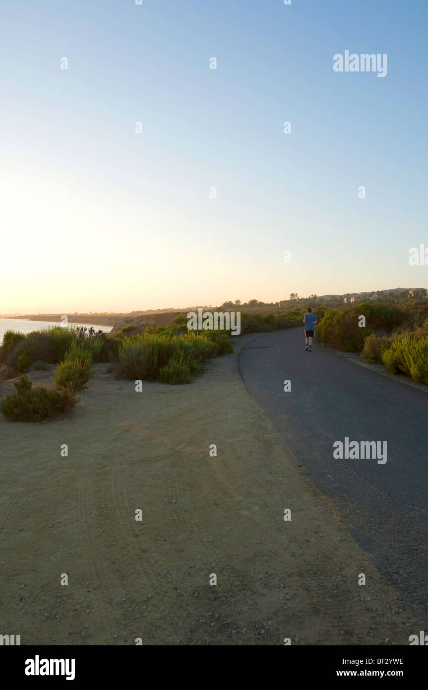 Man running along the a trail overlooking the ocean in Corona Del Mar ...