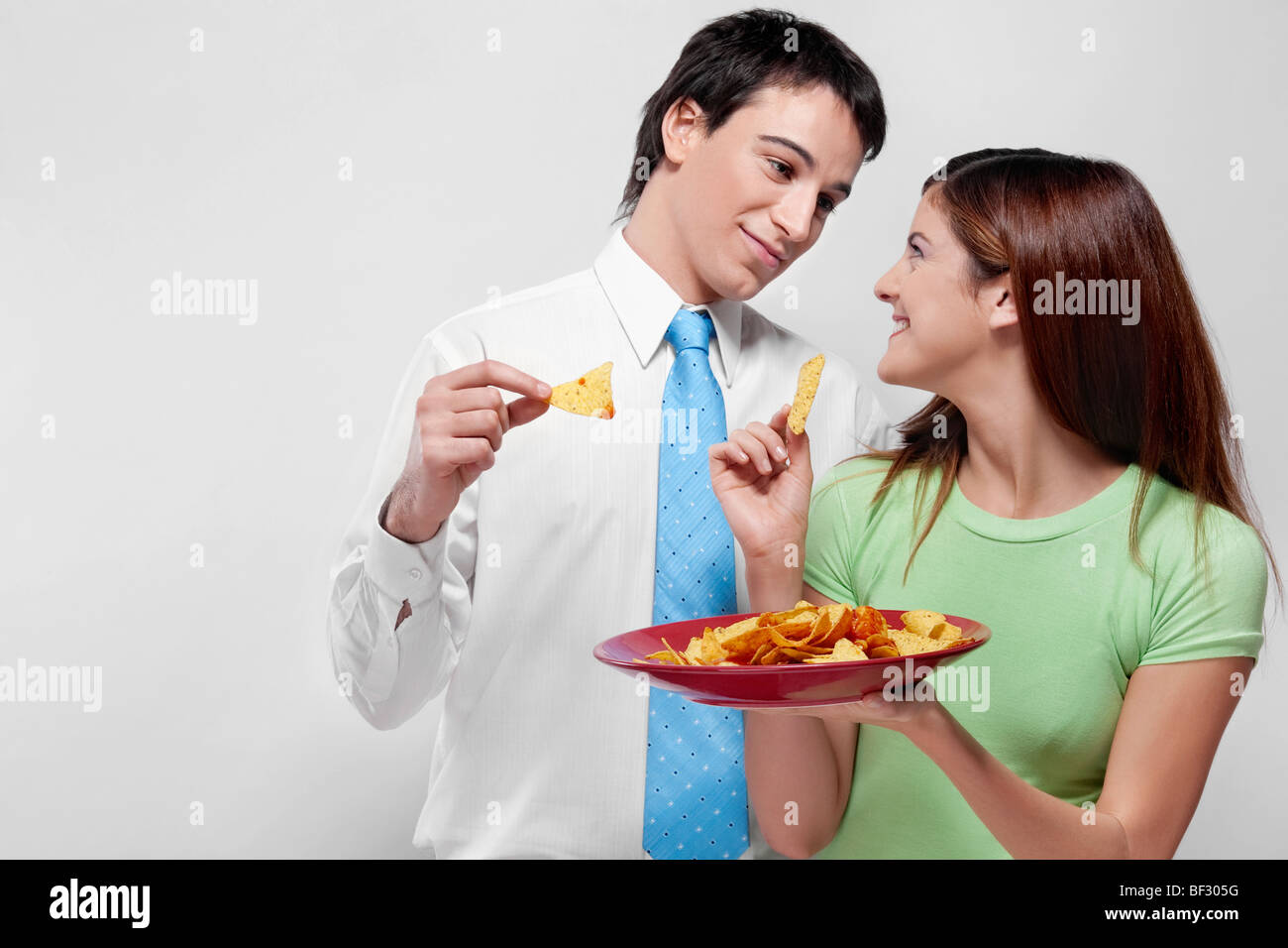 Couple eating nachos Stock Photo - Alamy