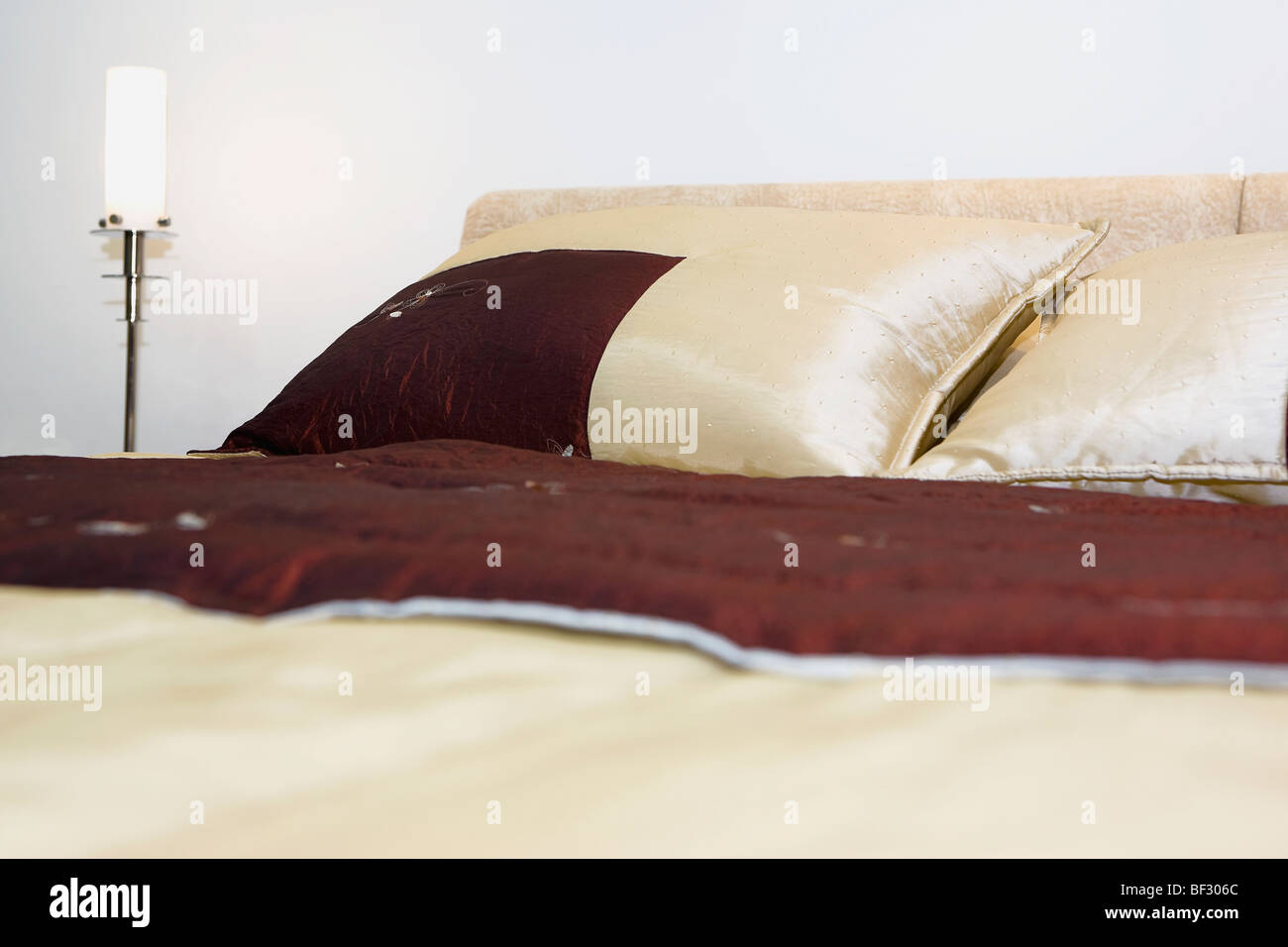 Lamp lit up beside a bed Stock Photo - Alamy