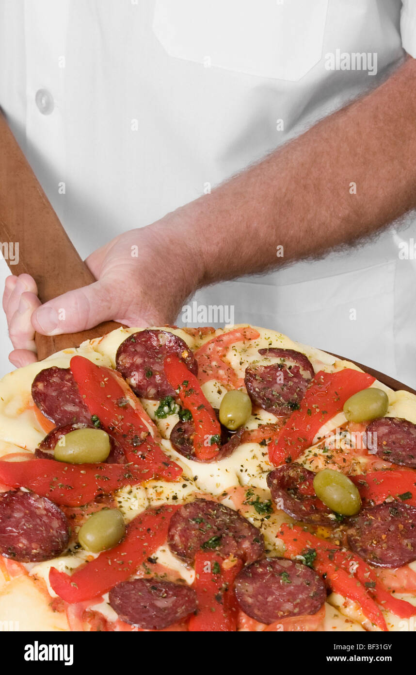 Chef holding a pizza on a pizza peel Stock Photo - Alamy