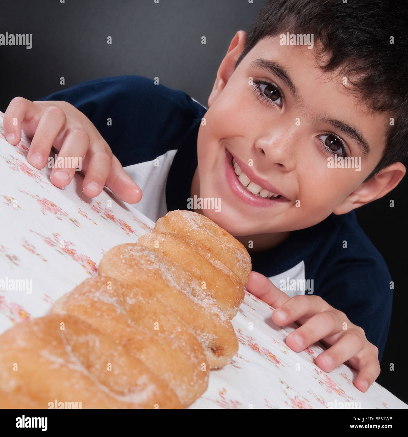 Boy with a line of donuts at a table Stock Photo - Alamy