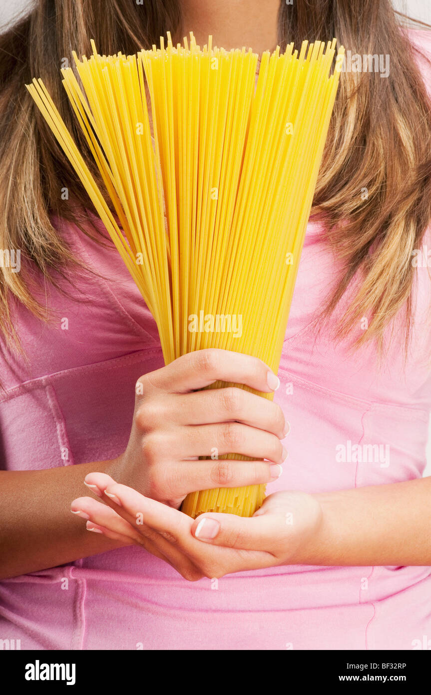 Woman holding uncooked spaghetti Stock Photo - Alamy