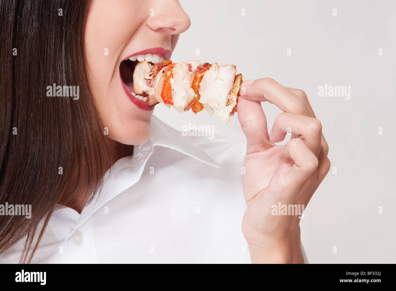 Close-up of a woman eating a shish kebab Stock Photo - Alamy