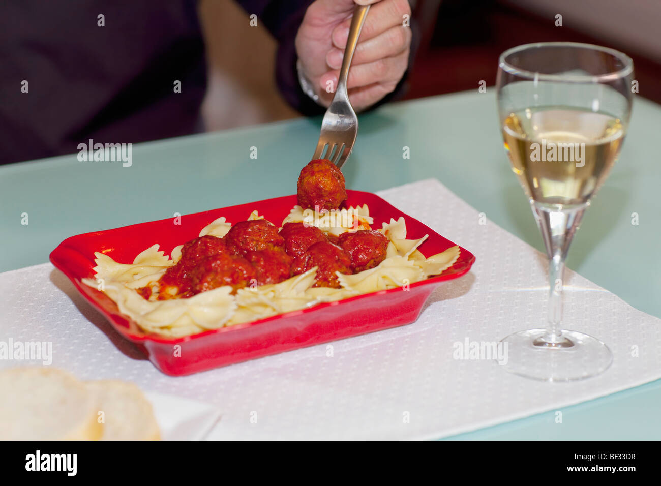 Man eating farfalle pasta and meatballs Stock Photo - Alamy