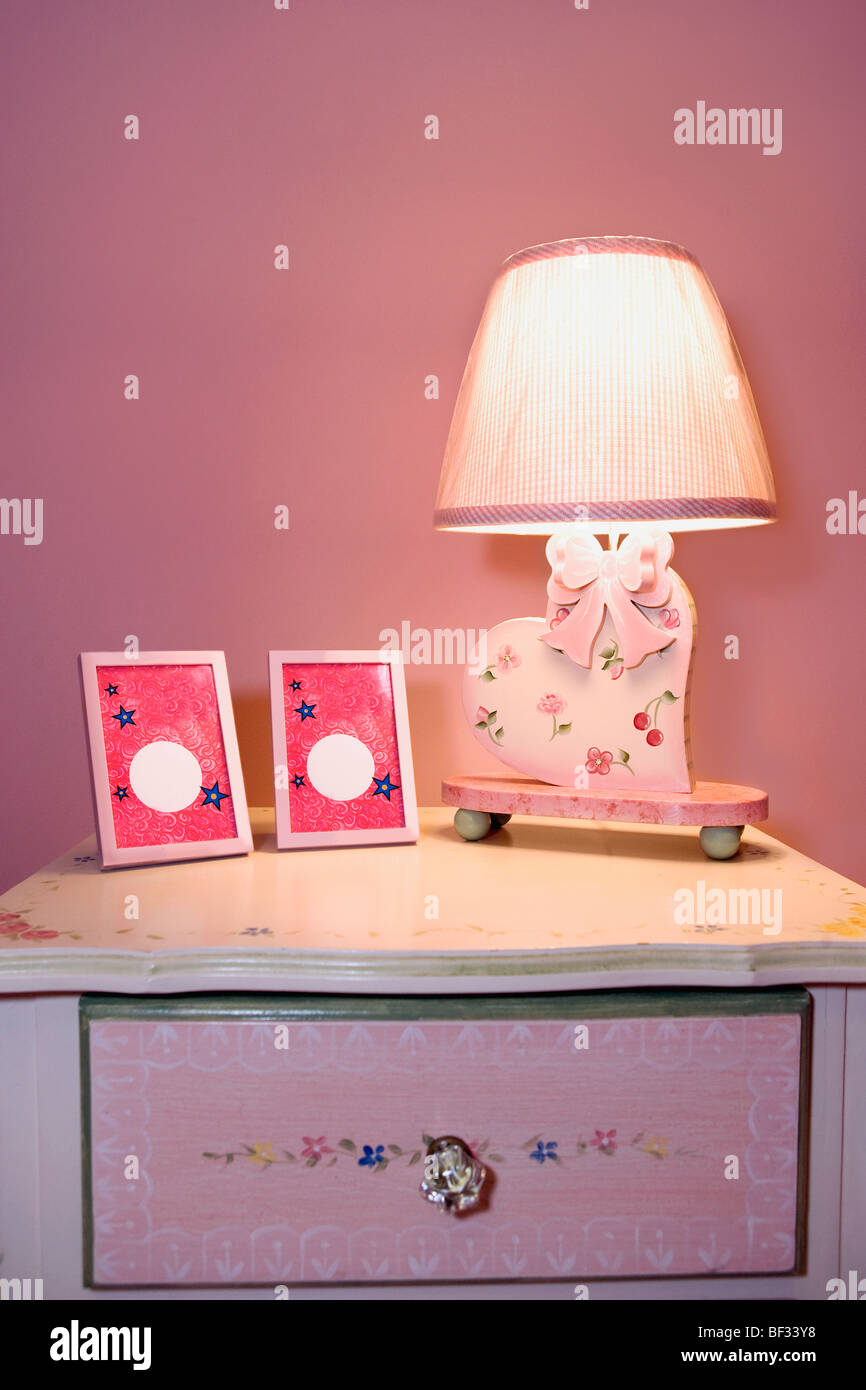 Picture frames and a lamp on a night table Stock Photo - Alamy