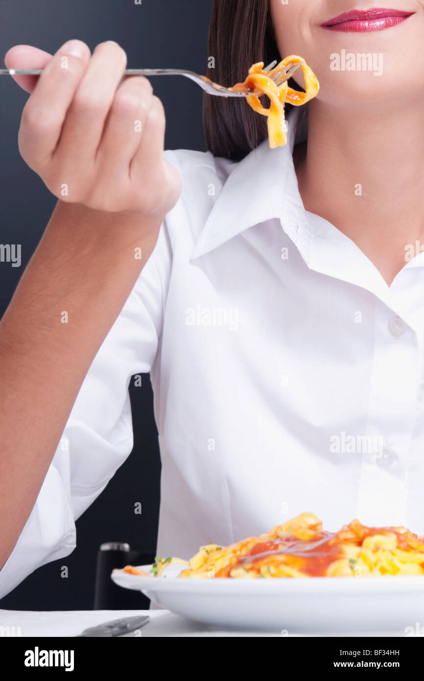 Mid section view of a woman eating pasta Stock Photo - Alamy