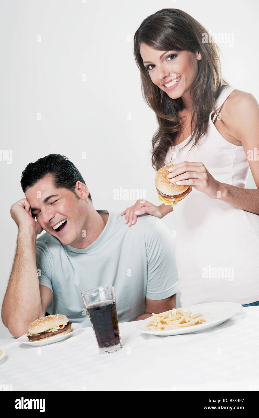 Couple eating hamburgers Stock Photo - Alamy