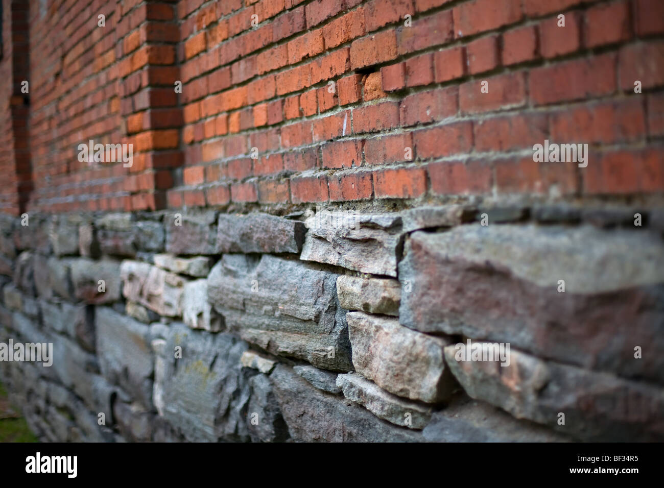 Red brick and stone make up the wall of a building. Shot at an angle ...