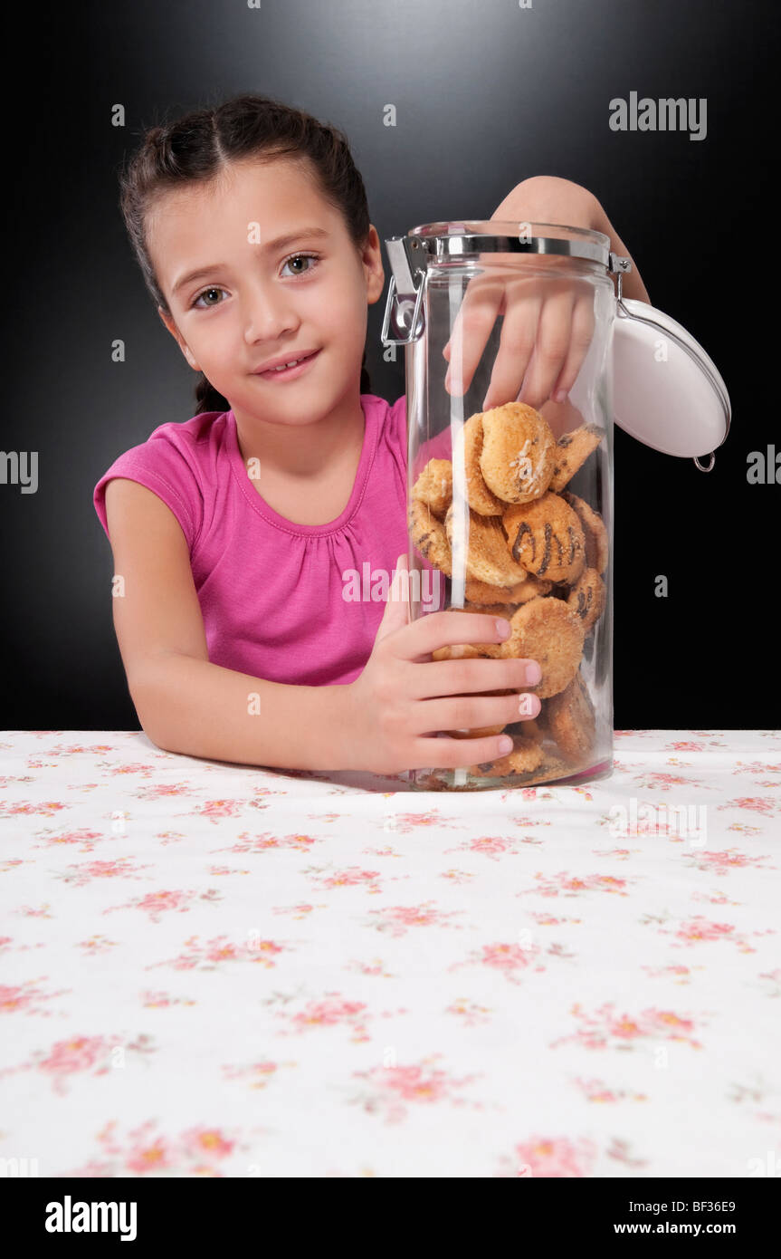 Girl putting her hand into a cookie jar Stock Photo - Alamy