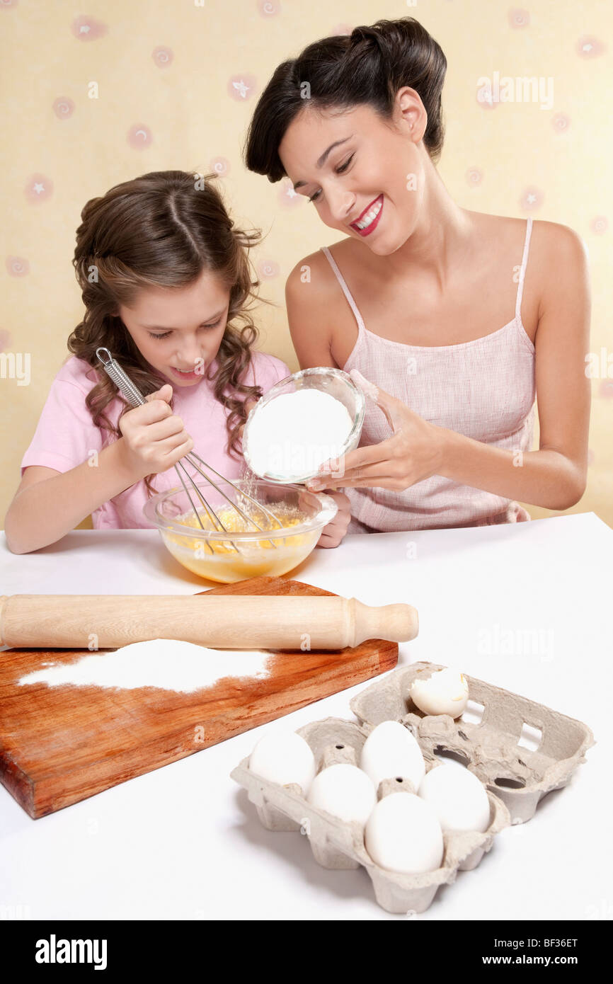 Girl helping her mother in cooking Stock Photo - Alamy