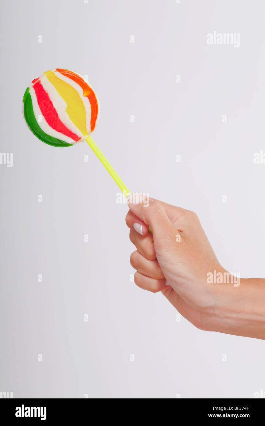 Close-up of a human's hand holding a lollipop Stock Photo - Alamy