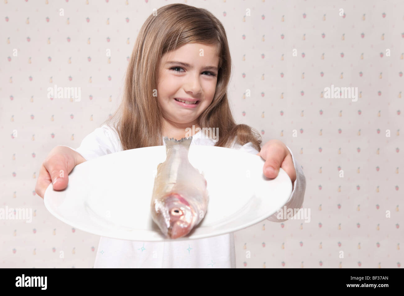 Girl frowning to see a raw fish Stock Photo - Alamy