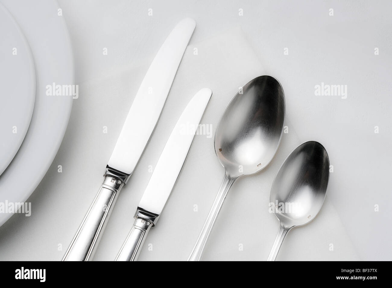 elegant table setting with silverware on white cloth Stock Photo - Alamy
