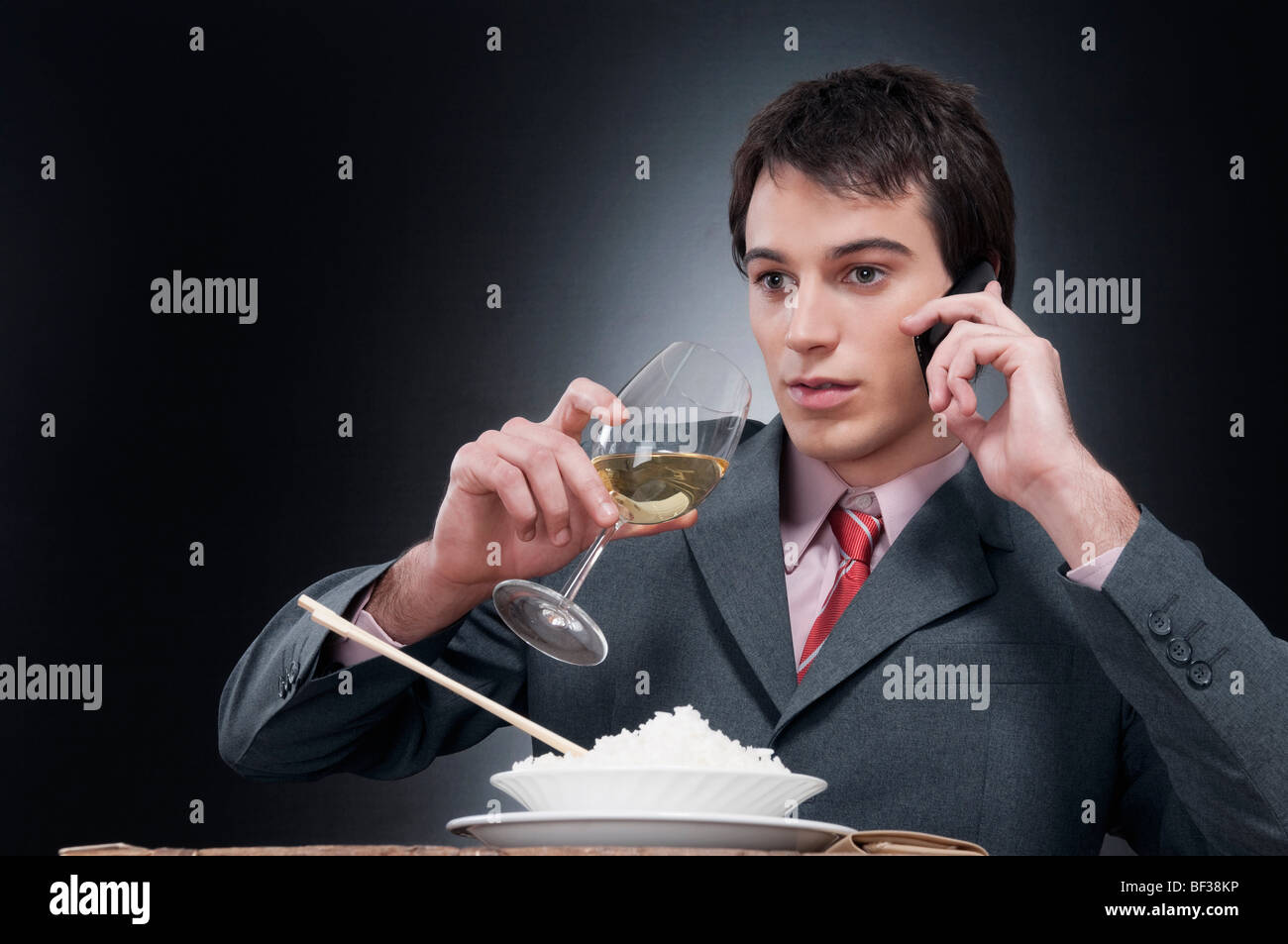 Businessman talking on a mobile phone while eating Stock Photo - Alamy