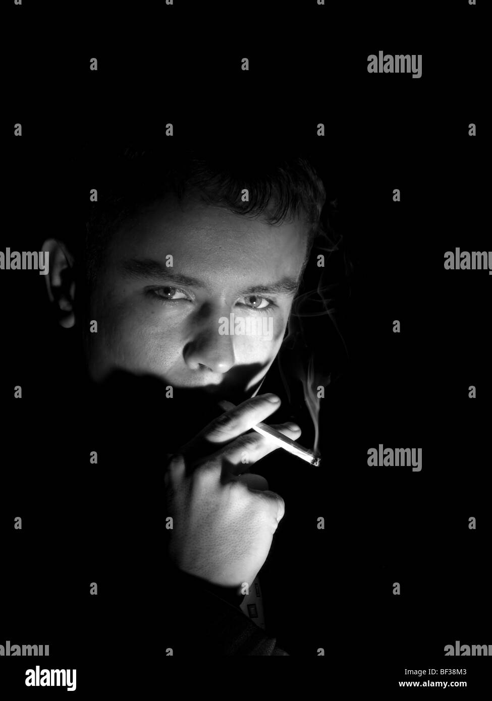 Young man in suit smoking cigarette looking into camera Stock Photo - Alamy
