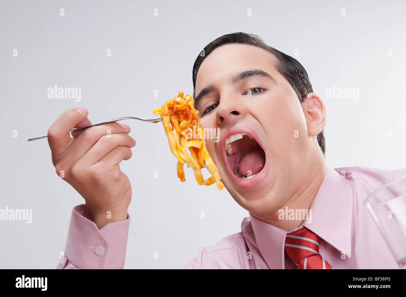 Close-up of a businessman eating pasta Stock Photo - Alamy